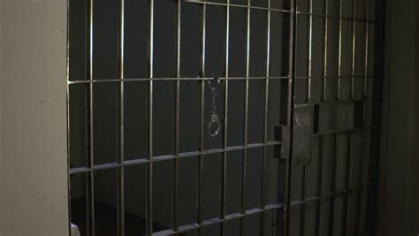 A Static Camera Closeup Of The Door Slamming Shut A Brick Jail Cell