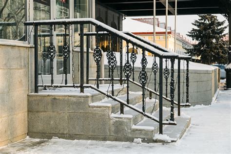 겨울 눈 시즌에 크리스마스와 새해 연휴를 위해 마술처럼 장식된 안뜰 계단 집 빛나는 화환은 저녁에 아름답게 반짝입니다 겨울 방학을위한 전형적인 거리 장식 겨울에 대한 스톡