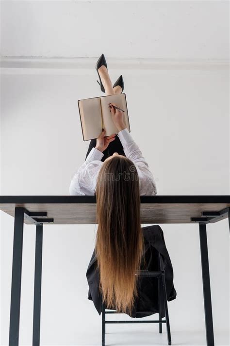 Woman Writing In Notebook Covering Face At Desk In Professional Setting Stock Image Image Of