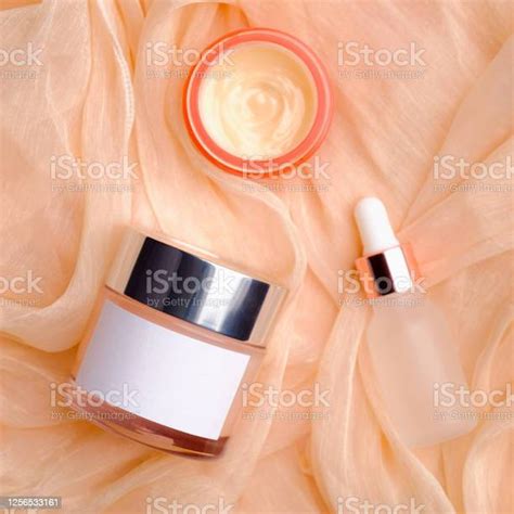 복숭아 색 원단에 보습제 크림과 바디 로션이 있는 화장품 항아리 플랫 레이 상단 보기 뷰티 제품 포장 디자인 메이크업 화장품에