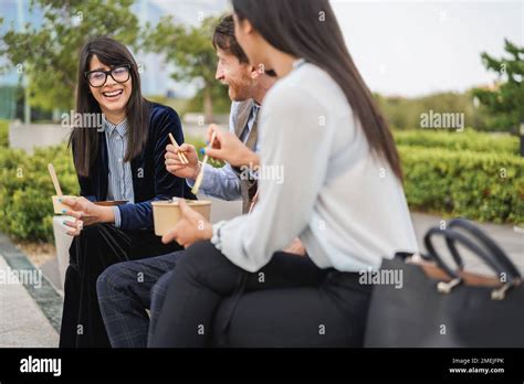 Business People Doing Lunch Break Outdoor From Office Building Focus On Left Girl Face Stock