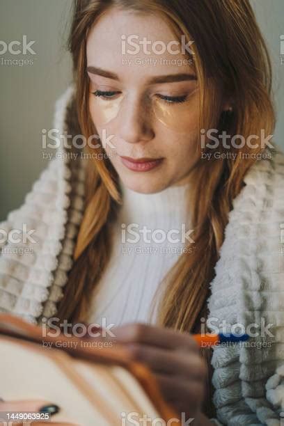 따뜻한 담요로 덮인 눈 밑 패치를 입은 여성의 초상화는 주말을 즐기며 메모를 하고 있습니다 엔터테인먼트와 레저의 개념 20 24