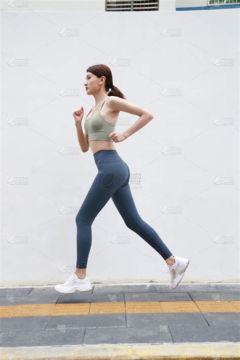 穿着运动服街头跑步摆拍的模特全身照