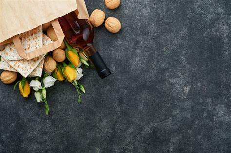유월절 페사 축하 개념입니다 Matzah 코셔 레드 와인 호두 흰색과 노란색 장미 모래 색깔 오래된 타일 벽 배경에 전통적인