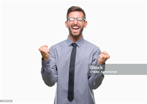 젊은 잘생긴 비즈니스 사람 고립 된 배경에 매우 행복 하 고 흥분 무기와 우승자 제스처를 하 고 웃 고 성공을 위한 비명 축 하