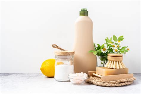 친환경 천연 세제 베이킹 소다 접시 브러쉬 레몬 꽃 흰색 배경에 비누가있는 항아리 모의 젖병을 곁들인 수제 클렌징용 유기농 재료