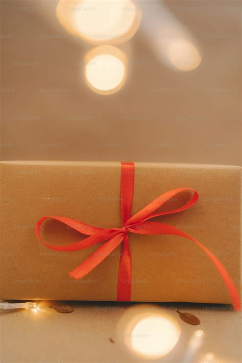 테이블 위에 빨간 리본이 달린 갈색 상자 사진 Unsplash의 크리스마스 이미지