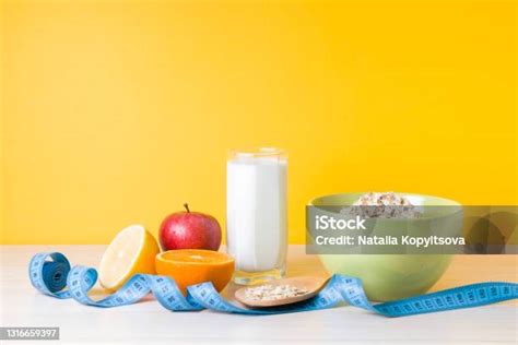 우유 과일 오트밀 한 그릇 탁자 위에 파란색 측정 테이프 노란색 배경 건강한 라이프 스타일 개념 적절한 영양 및 체중 감소 0