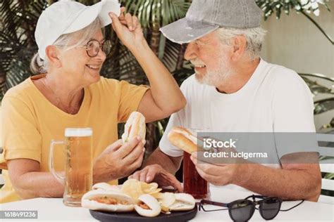 화창한 여름날 시원한 맥주 한 잔을 즐기며 샌드위치를 먹는 펍 레스토랑에서 행복한 노부부 2명에 대한 스톡 사진 및 기타 이미지