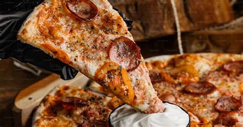 상자에서 피자 한 조각을 꺼내는 사람 사진 Unsplash의 마늘 딥 이미지