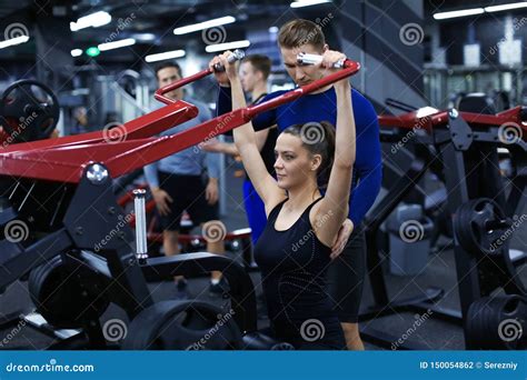 Sporty Woman Doing Exercises Under Supervision Of Her Personal Trainer