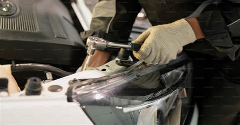 수리 중 엔진의 세부 사항을 고정하면서 수공구를 사용하여 유니폼을 입은 현대 자동차 정비 센터의 젊은 작업자의 장갑을 낀 손 사진 Unsplash의 유지 보수 엔지니어 이미지