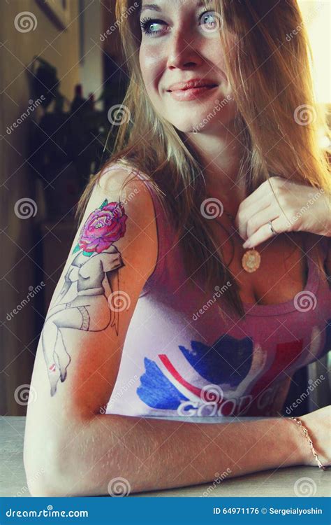 Young Beautiful Hipster Woman With Blonde Hair And Tattoo Hands In Cafe