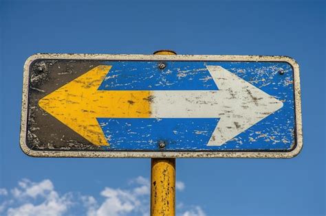 A Yellow Arrow Pointing To The Left With The Blue Sky In The Background