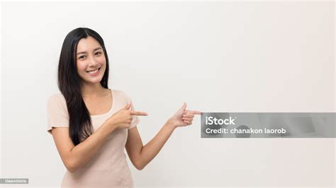 빈 공간에 손가락을 가리키는 아름다운 아시아 여자 고립된 흰색 배경에 미소 짓는 여성 서 포즈 매력적인 십대 소녀 25 텍스트에