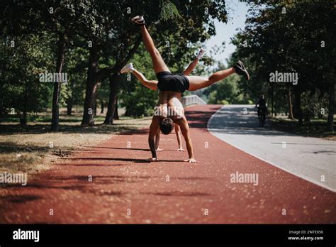 Fit Sportspeople A Man And A Woman Practice Cartwheels In A Sunny