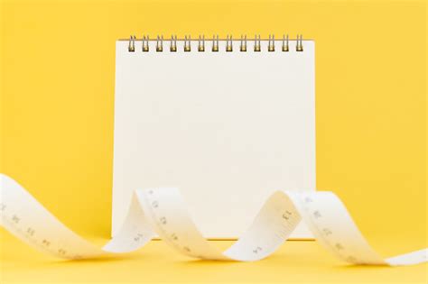 영양 다이어트 및 손실 체중 알림 Tailer 디자이너 또는 가구 및 집 개념에 대 한 측정 도구 노란색 배경에 흰색 종이 측정 테이프와 텍스트를 넣어 빈 바탕 화면 종이