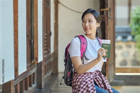 한국의 옛날 전통 가옥 마루에 걸터 앉아서 여권 과 항공권을 바라보고 있는 아시아 한국 여자 모델 Stock Foto