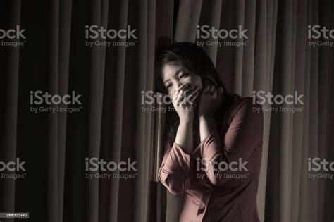 극적인 실내 젊은 슬 프 고 우울 아시아 중국 여자 울고 절망 실의 고통 우울증과 어두운 빛 집에서 불안의 커튼 슬픔 개념에 창