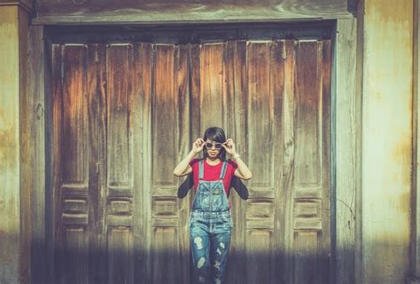 Premium Photo Woman Holding Sunglasses While Standing Against Wall