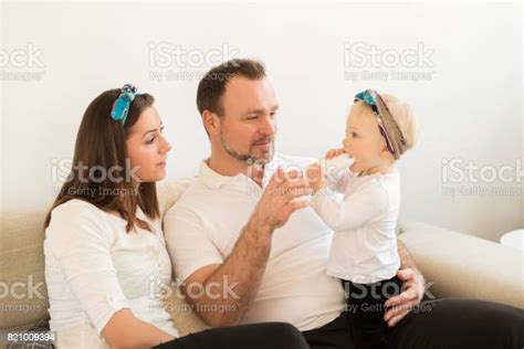 소파에 앉아서 그들의 아름 다운 딸가지고 노는 행복 한 부모 가족 값 합니다 어머니에 대한 스톡 사진 및 기타 이미지 어머니 아기 아버지 Istock