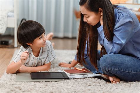 아시아의 어머니는 아들과 함께 집에 일합니다 온라인 학습 교육을 위한 아이를 가르치는 엄마 새로운 정상적인 라이프 스타일과 가족