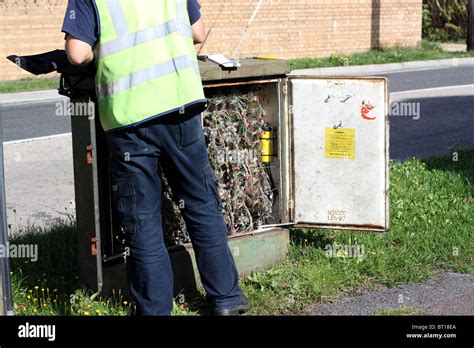 A British Telecom Telephone Engineer Examining A Junction Box Or