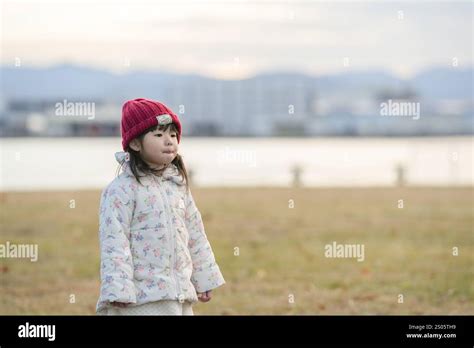 A 3 Year Old Japanese Girl Is Walking On A Cold Winter Night In A