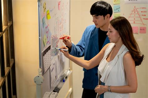 똑똑한 비즈니스 남자와 예쁜 여자는 자신의 프로젝트를 계획하는 화이트 보드에 펜 쓰기를 사용 남자에 대한 스톡 사진 및 기타 이미지 Istock