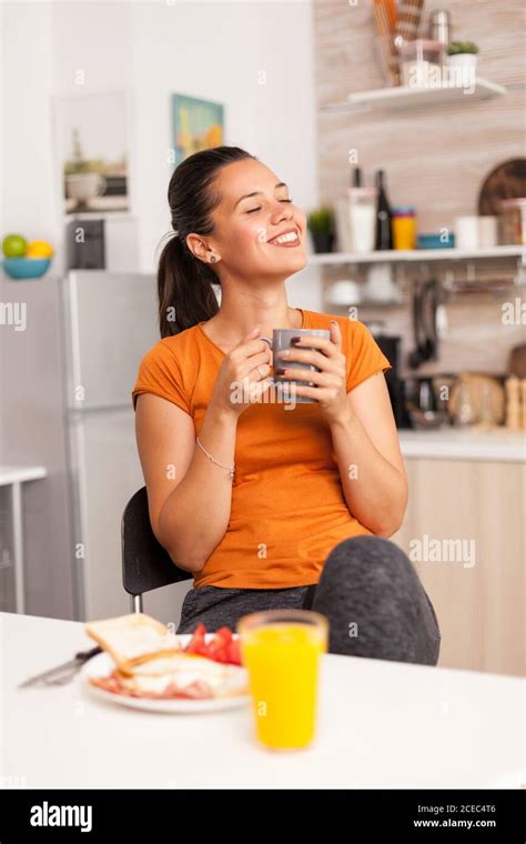 Wife Enjoying Her Free Time Drinking A Cup Of Coffee In The Kitchen In