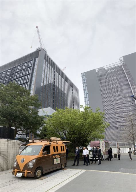 北側緑地でキッチンカーに並ぶランチ客。福岡ビル跡地で建設が進む再開発ビル（奥）や、既に完成した天神ビジネスセンター（右）に囲まれている