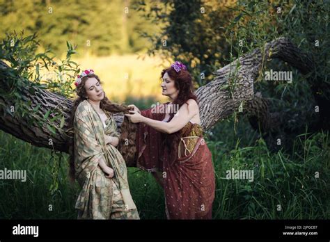 Portrait Of Two Beautiful Mature Women Dressed In A Nymph Style Dress Inspired By Early Th