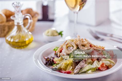 고기 토마토 바질 어린 새싹 오이 양파 샐러드를 칼 올리브 오일 와인 한 잔과 함께 밝은 배경의 접시에 담은 샐러드 0명에 대한