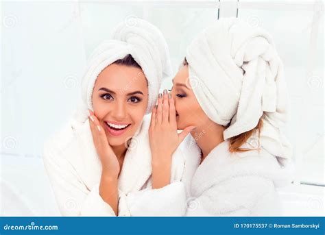 Girl In Bathrobe And Towel On Her Head Telling Secret To Her Sister