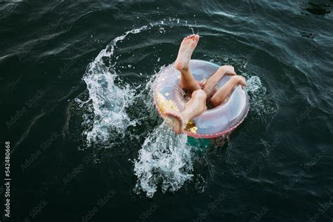 Kid S Limbs Sticking Out Of Swim Float In Lake Stock Photo Adobe Stock