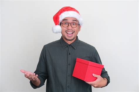 크리스마스 모자를 쓴 아시아 남자가 놀란 표정으로 선물 상자를 가져온다 2022년에 대한 스톡 사진 및 기타 이미지 2022