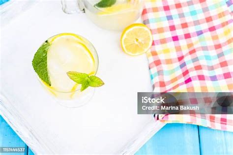 푸른 나무 테이블에 유리에 얼음과 레몬 슬라이스 및 민트와 레모네이드 과일과 비타민과 함께 여름 차가운 상쾌한 음료 감귤류