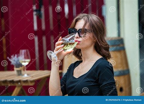 Beautiful Young Woman Drinking White Wine On The Terrace Of A
