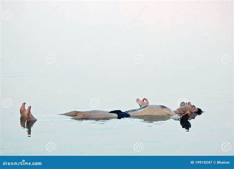 Man Floating In A Glassy Water Of Dead Sea Royalty Free Stock