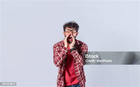 안경을 쓴 잘 생긴 남자는 발표를 외치며 고립되어 있었다 발표하고 소리 지르는 사람 발표를 외치는 남자의 개념 몸짓에 대한 스톡
