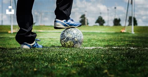 검은 바지와 파란색과 흰색 나이키 축구 공을 입은 사람이 푸른 잔디 필드에 사진 Unsplash의 무료 의복 이미지