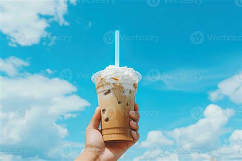 Hand Holding Iced Coffee In A Plastic Cup With A Blue Sky And Cloud Background Ai Generated