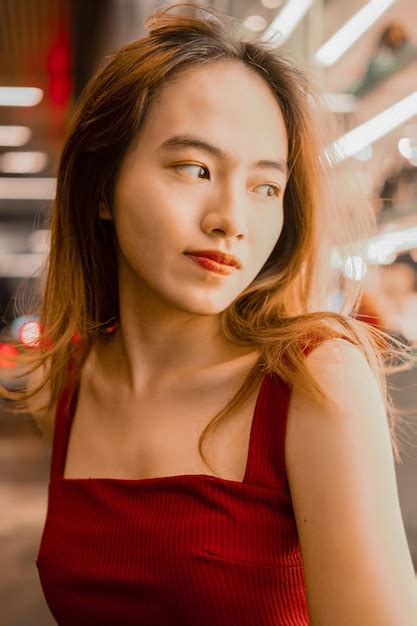Premium Photo A Woman In A Red Dress Stands In Front Of A Street Light