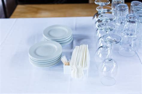 Set Of Clean Dishes And Glasses On Table Against White Background Stock