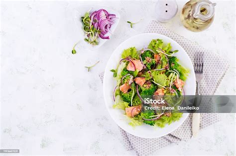 구운 생선 연어 브로콜리 양상추 붉은 양파와 드레싱의 샐러드 생선 메뉴 해산물 연어 상단 보기 오버헤드 건강한 생활방식에 대한