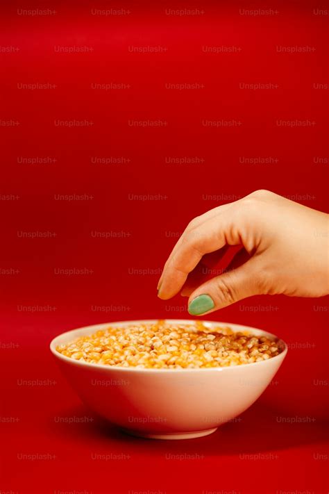 Foto La Mano De Una Mujer Metiéndose En Un Tazón De Maíz Granos De