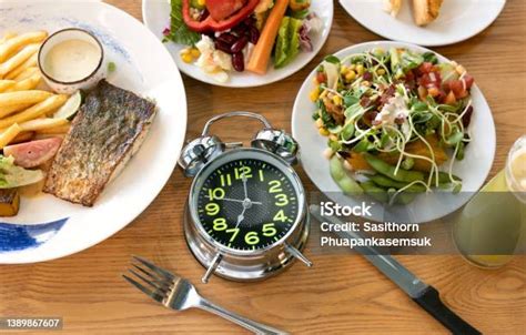 다이어트 계획 이미지를 위한 건강한 생활 습관으로 아침 식사 중 간헐적인 단식을 하는 알람 시계 선택 먹기에 대한 스톡 사진 및