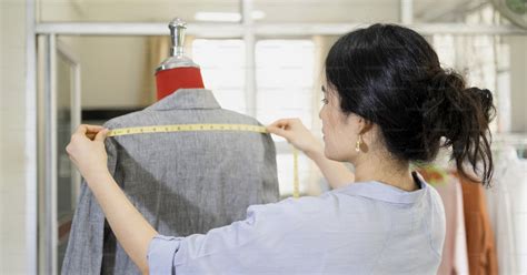 근접 촬영 젊은 여성 재단사가 마네킹에 재킷을 측정하고 있다 사진 Unsplash의 산업 이미지