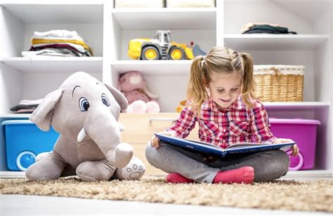 Adorable Petite Fille Assise Sur Le Tapis Et Lisant Un Livre Pour Son