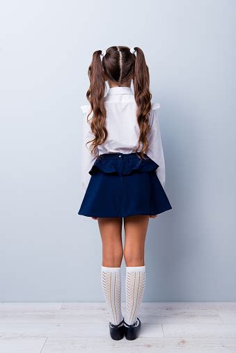공식적인 백색 블라우스 셔츠 짧은 파란색 치마 각 반 신발에 곱슬 땋은 좋은 사랑 스러운 세련 된 여자의 샷된 후면 다시 보기